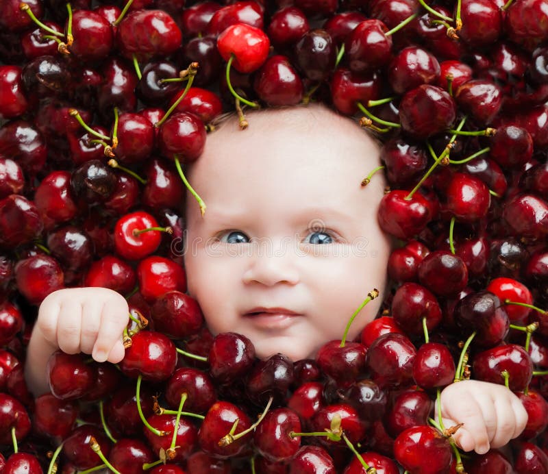 The Baby`s Face and Arms are Peeking Out of the Red Cherry, the Baby is ...