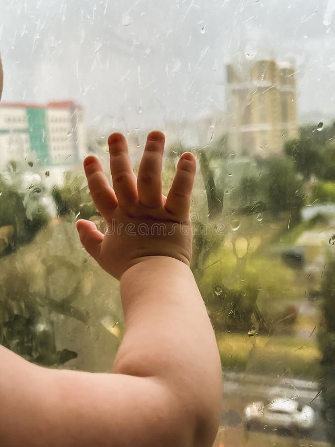 Baby S Little Hand on the Cold Glass of the Window during the Rain ...