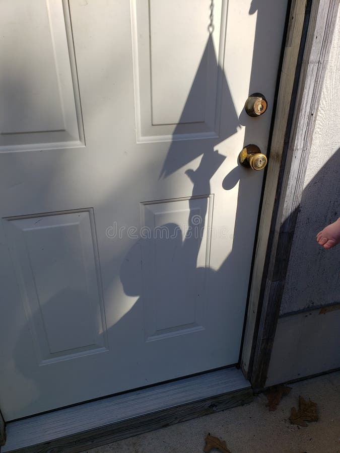 Shadow reaching on door stock photo. Image of windchime - 162265740