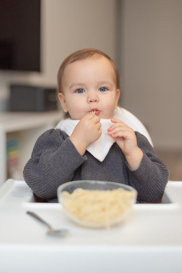 Baby Sits on a High Chair and Eats with His Hands, Independent Feeding ...