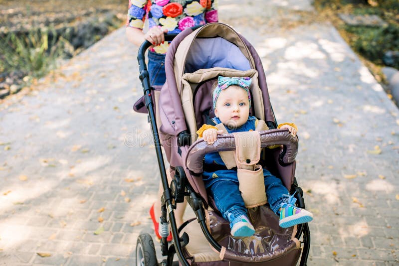 Baby is Sitting on Carriage Alone. Baby in Sitting Stroller on Nature ...