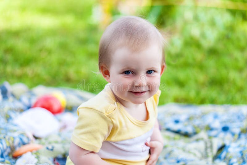 A Baby is Sitting on Plaid on the Field Stock Image - Image of ...