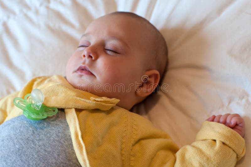 A Baby Sleeps in the Bed with Her Pacifier Stock Photo - Image of ...