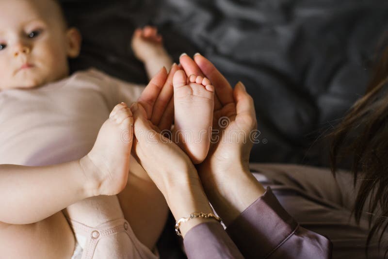 Baby Son`s Leg in the Palms of a Happy Mom Stock Photo - Image of ...