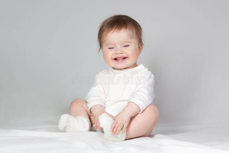 Baby squints and smiles, stock photo. Image of person - 214894982