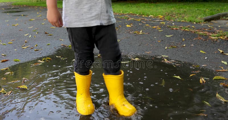 Baby Stomping through Puddles in Yellow Rubber Boots Stock Video ...