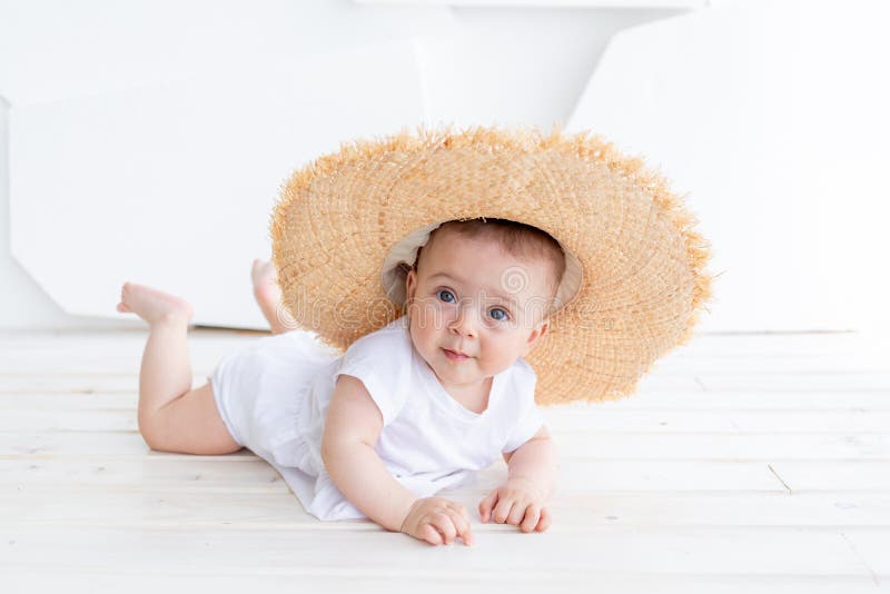 A Baby in a Straw Hat is Lying in a Bright Room Stock Photo - Image of ...