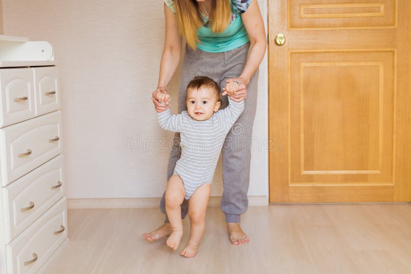 Baby Taking First Steps with Mother Help Stock Photo - Image of ...