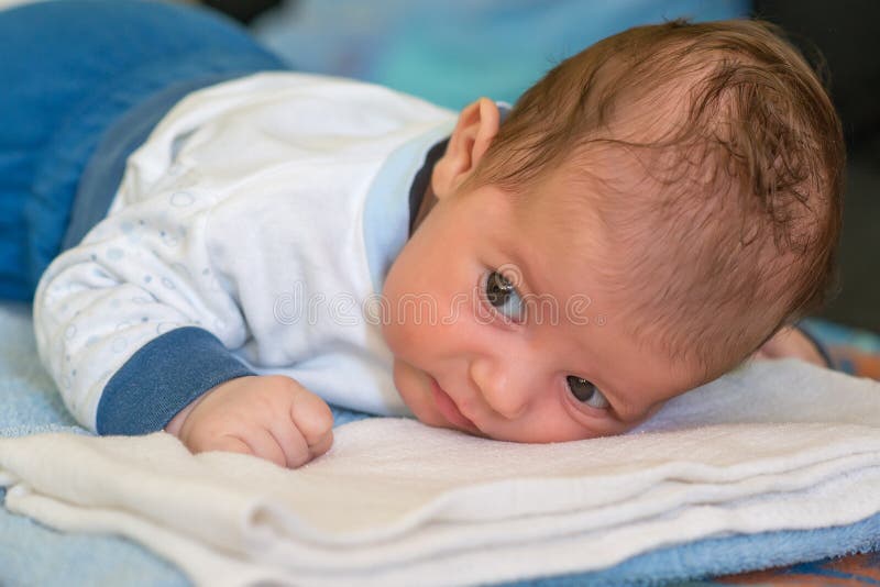 A Baby Two Months Old is Lying on the Stomach and Raising Her Head ...