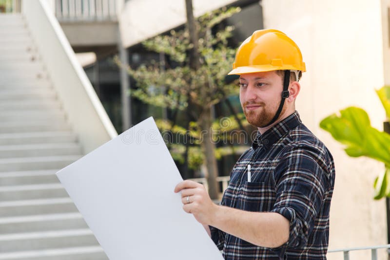 Engineer Holding Blueprint with Building Background. Stock Image ...