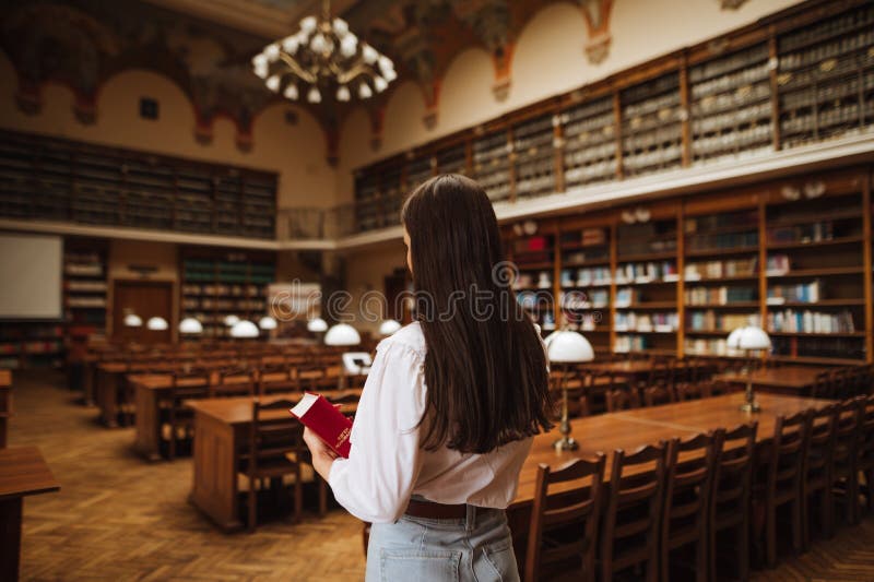 Back of Female Student in University Campus Library with Book in Hand ...
