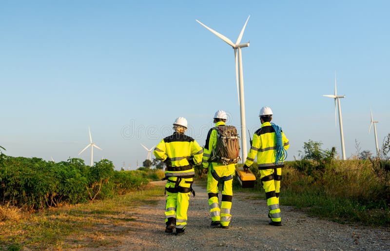 Back of Group of Wind Turbine or Windmill Workers or Technicians Carry ...