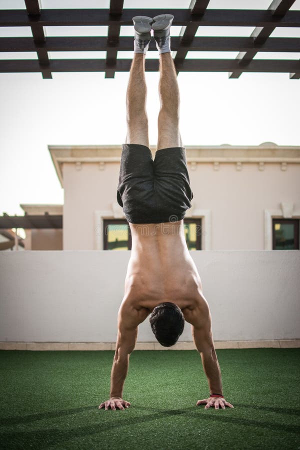Back of Handsome Shirtless Man Doing Handstand Exercise Outdoors Stock ...