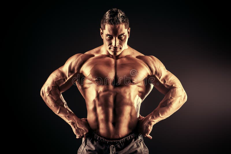 Bodybuilder Posing. Fitness Muscled Man on Dark Background. Stock Photo ...