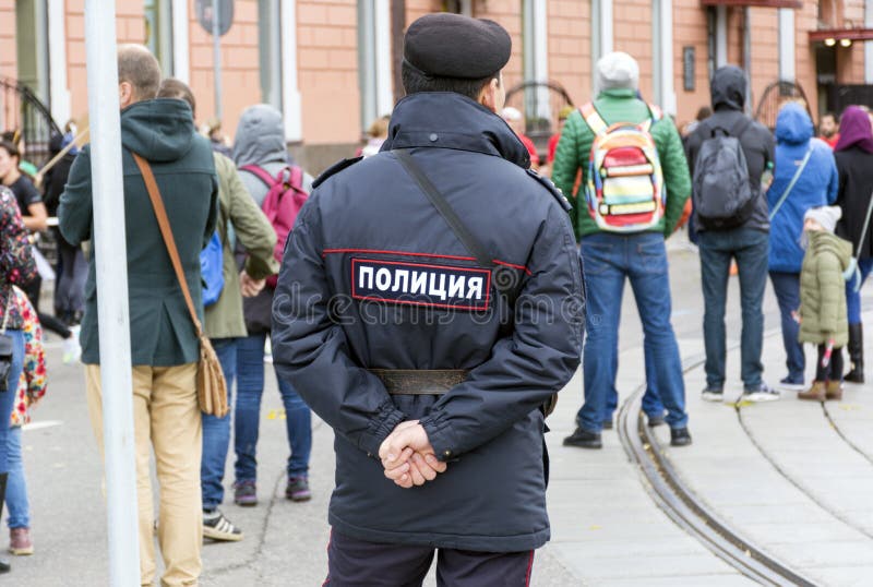 Back of a Uniformed Policeman among the People on the Street Editorial ...