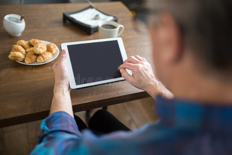 Senior Man Holding Tablet at Kitchen Table Stock Photo - Image of ...