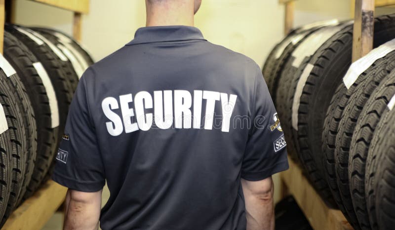 Back of a Security Guard Patrolling Inside the Warehouse of Tires ...