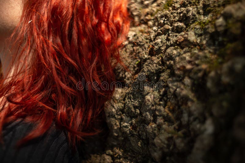 Back Shot of a Red Hair Female in Front of Rough Tree Trunk Bark in the ...