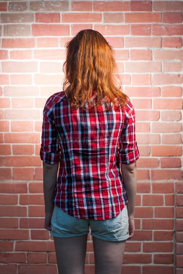 Back Side View of a Redhead Female Befor Red Brick Wall. Stock Image ...