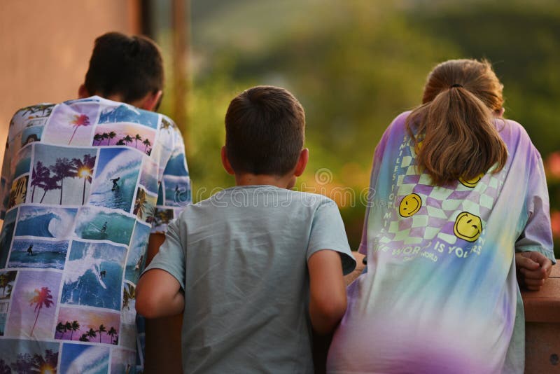 Back of Three Children Looking Down from Balcony or Terrace Stock Photo ...