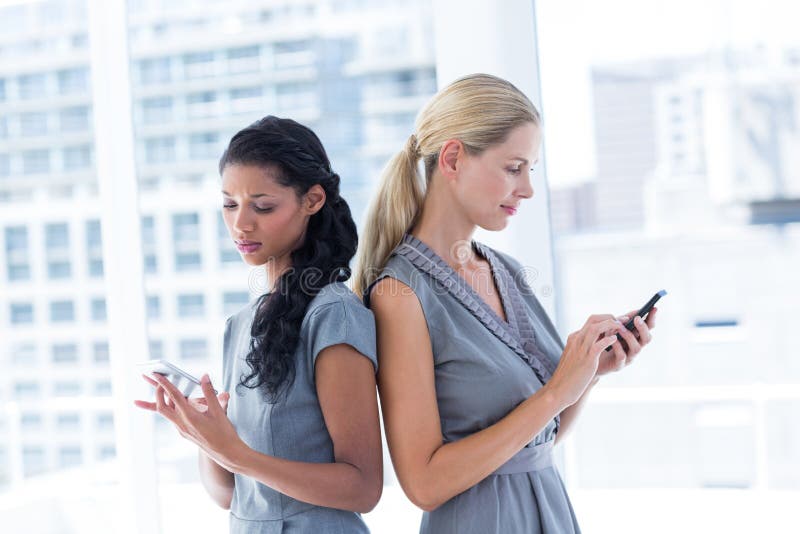 Back To Back Businesswomen Texting Messages Stock Photo - Image of ...