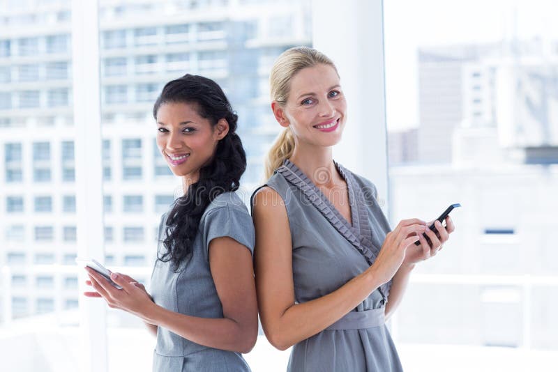 Back To Back Businesswomen Texting Messages Stock Image - Image of ...