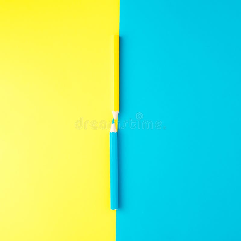 Back To School Concept with Two Yellow and Blue Crayons on Yellow and ...