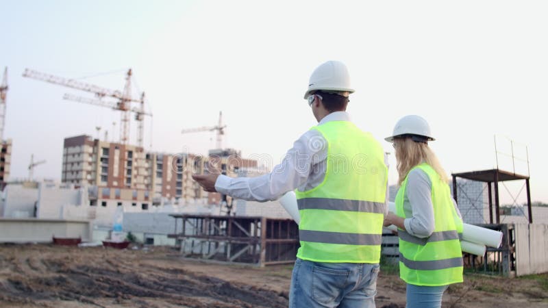 Back Turned Engineer and Controller at Construction Site Reviewing ...