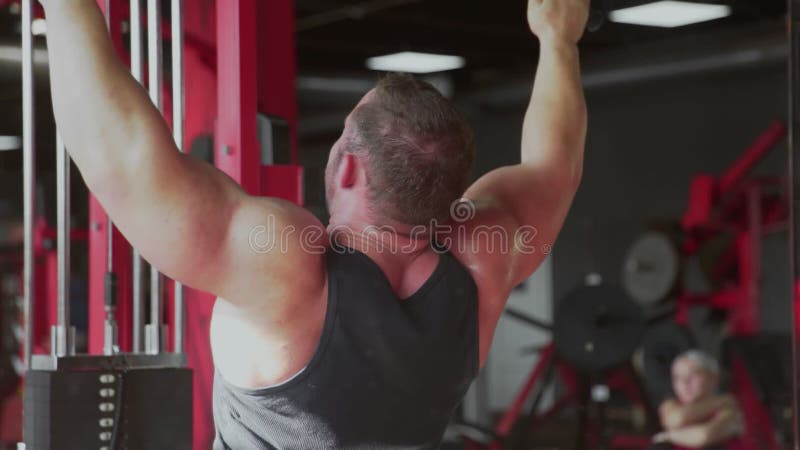 Back View of an Attractive Man Bodybuilder Performing Lat Pulldown at ...