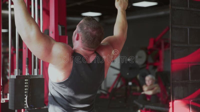 Back View of an Attractive Man Bodybuilder Performing Lat Pulldown at ...
