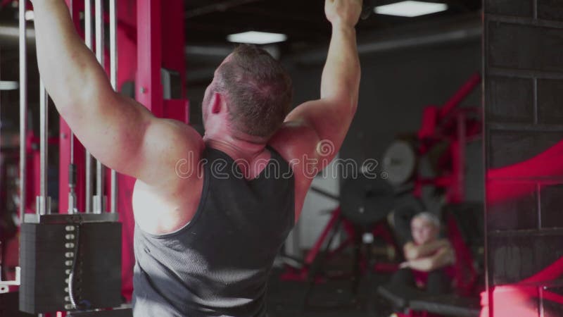 Back View of an Attractive Man Bodybuilder Performing Lat Pulldown at ...