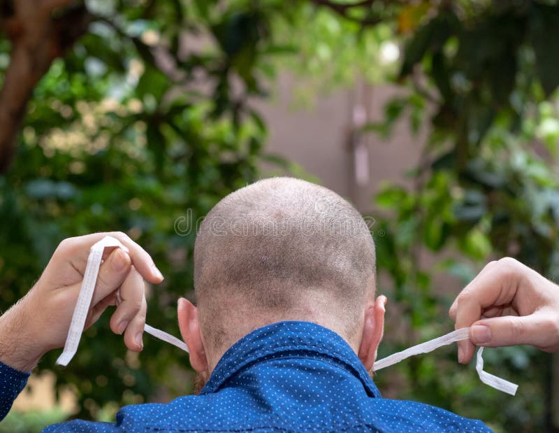 Back View of a Bald Man Putting on a Face Mask Stock Photo - Image of ...