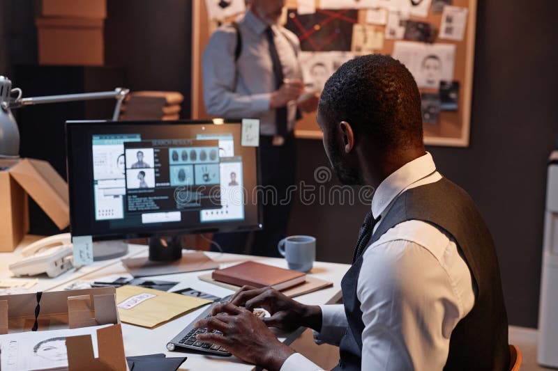 Back View of Black Detective Using Computer at Workplace Stock Photo ...