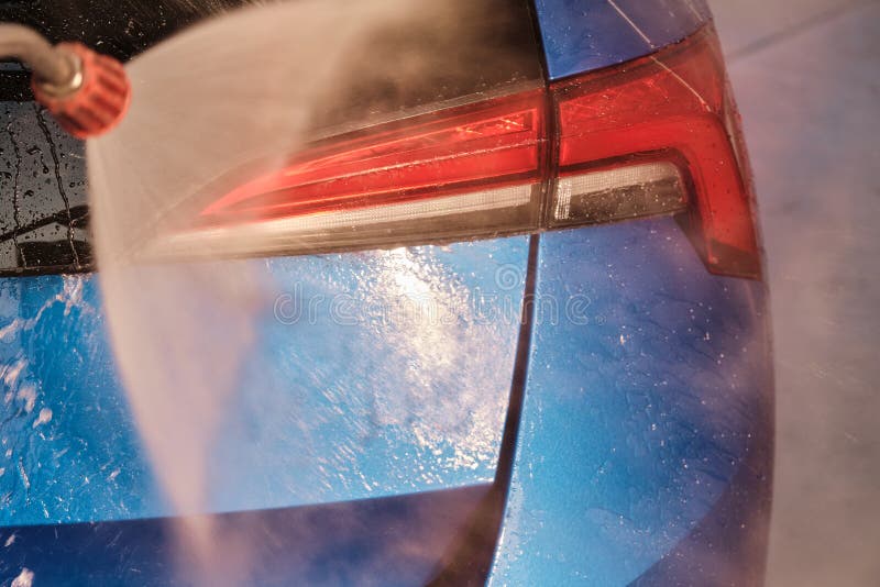 Back View of a Blue Car Washing Under High Pressure Water. Self Service ...