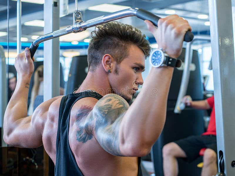 Back View of Bodybuilder Exercising on Simulator Stock Photo - Image of ...