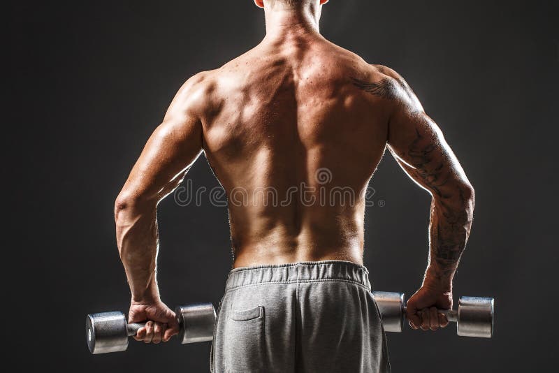 Back View of Bodybuilder Training with Dumbbell on Black Stock Image ...