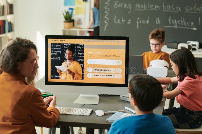 Back View of Boy Using Computer in School with Teacher Stock Photo ...