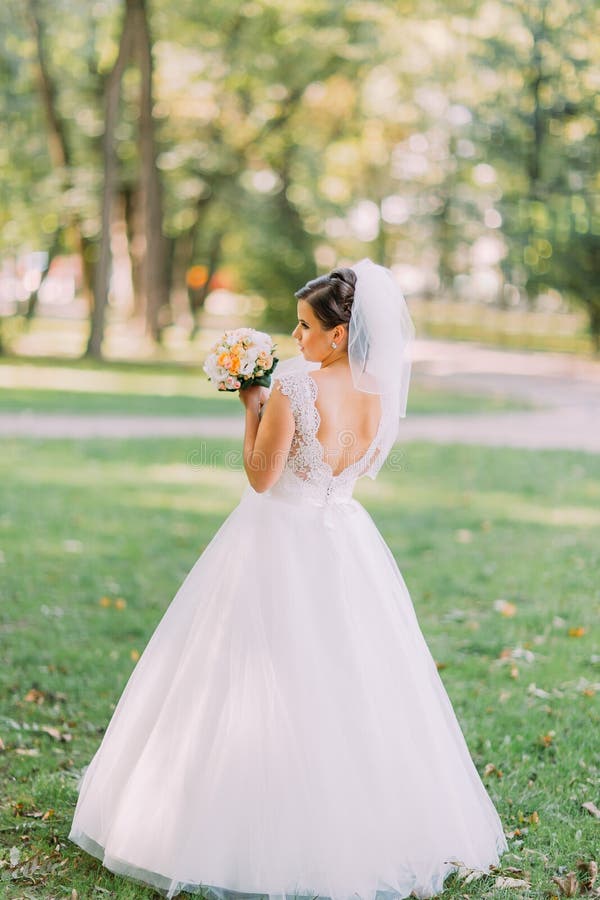 The Back View of the Bride Holding the Yellow Wedding Bouquet at the ...