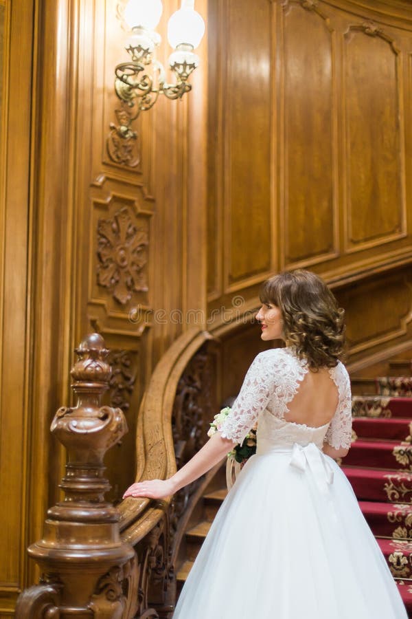 The Back View of the Bride Standing on the Stairs of the Old Building ...