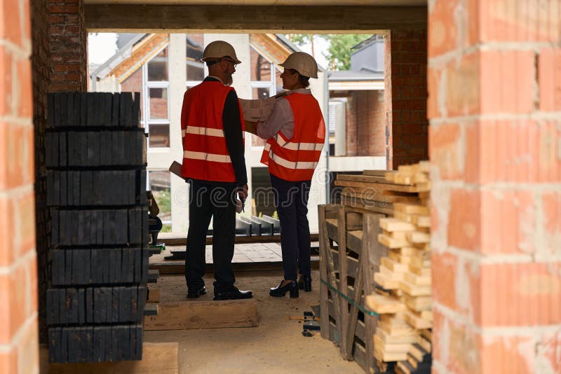 Building Inspector and Contractor Using Blueprints during Inspection ...