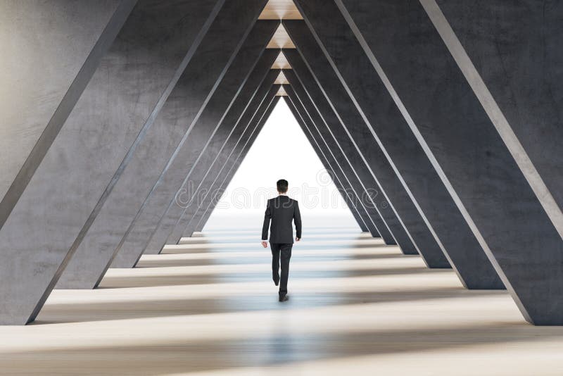 Back View of Businessman Walking in Abstract Concrete Triangle Corridor ...