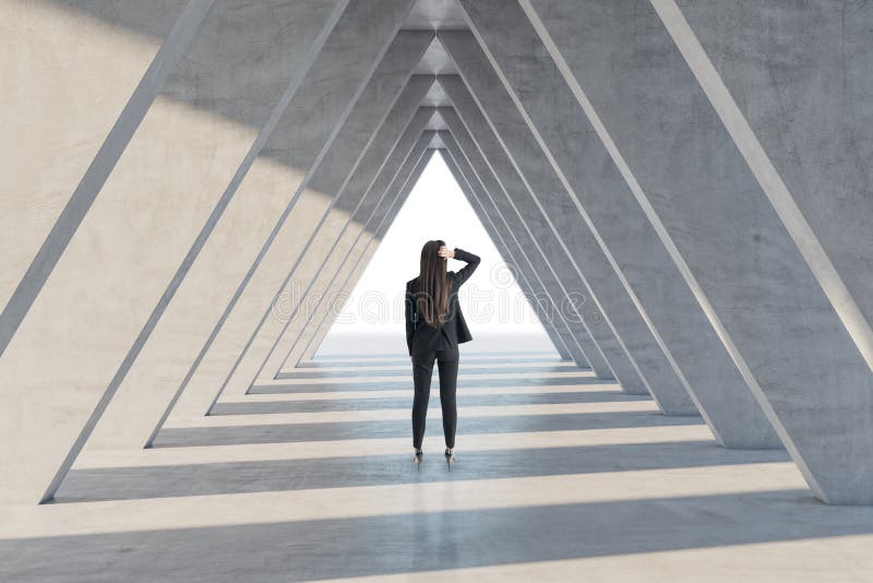 Back View of Businesswoman in Abstract Concrete Triangle Corridor ...