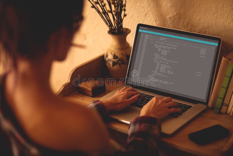 Back View Of Caucasian Female Programmer Sitting At Desk Using Laptop With Coding On Screen