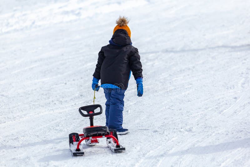 Back View of Child in Pulling Sledge and Running Up Snowy Slope Stock ...
