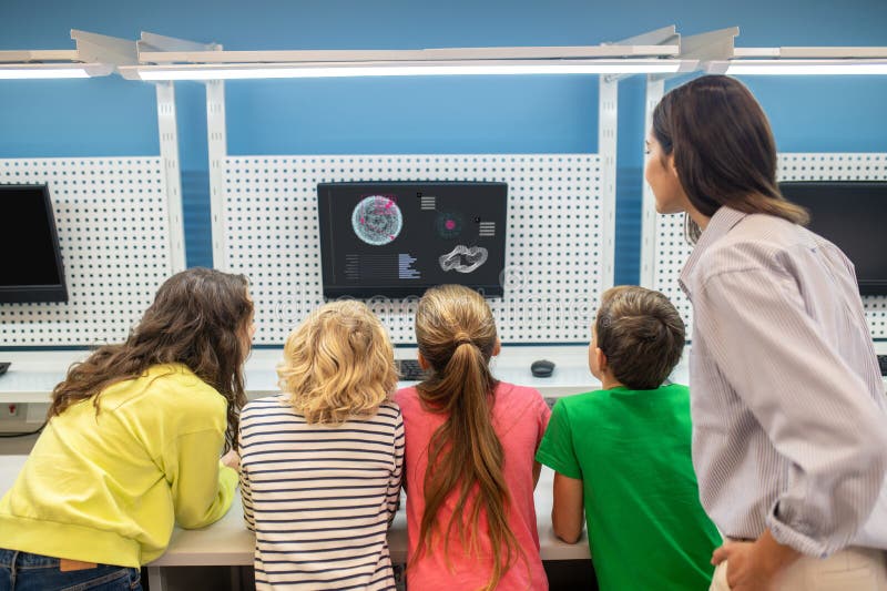 Back View of Children and Woman Looking at Screen Stock Image - Image ...