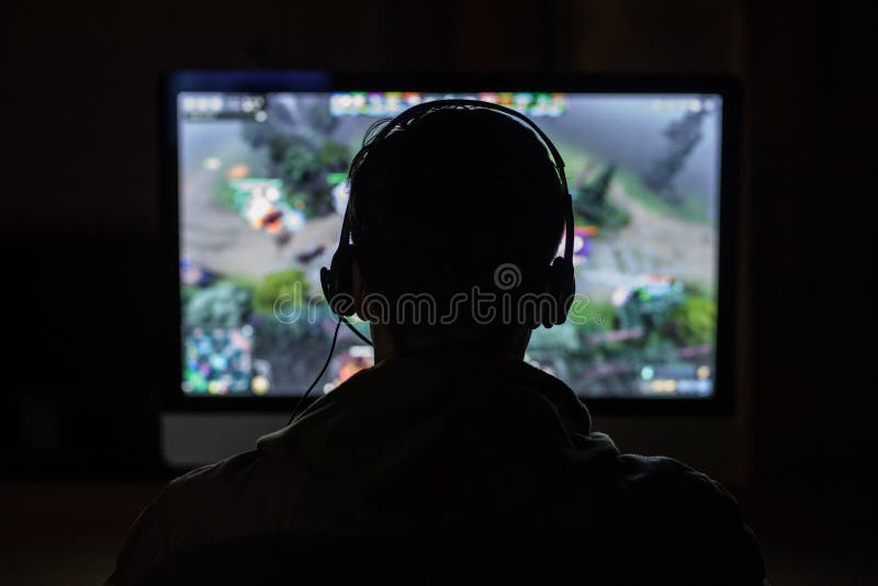 Back View of Concentrated Young Gamer in Headphones and Glasses Using ...