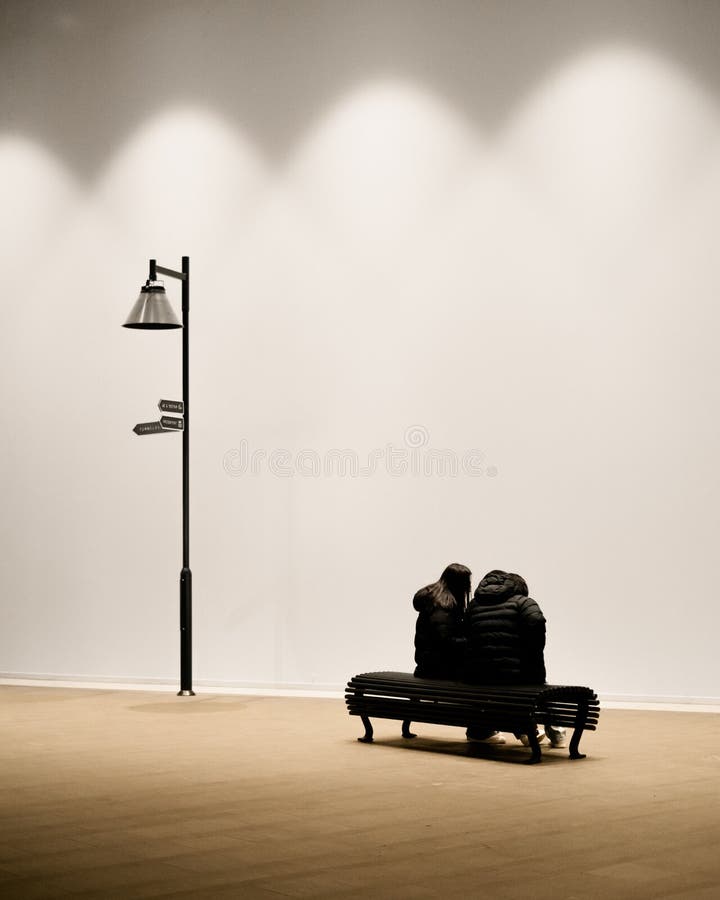 Back View of a Couple Sitting on Wooden Bench Inside a Minimalistic ...