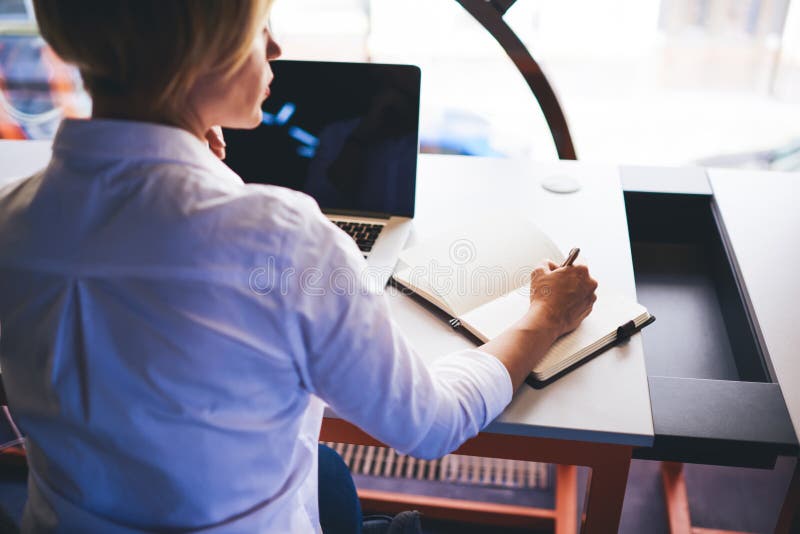 Crop Woman with Laptop Taking Notes in Notebook Stock Photo - Image of ...