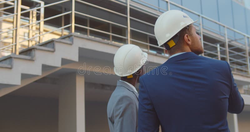 Back View of Diverse Industrial Engineers Planning on Blueprint at Work ...