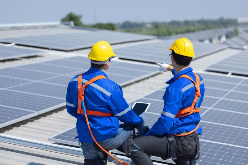 Back View of Engineer Checking on Solar Panel on the Factory Rooftop ...